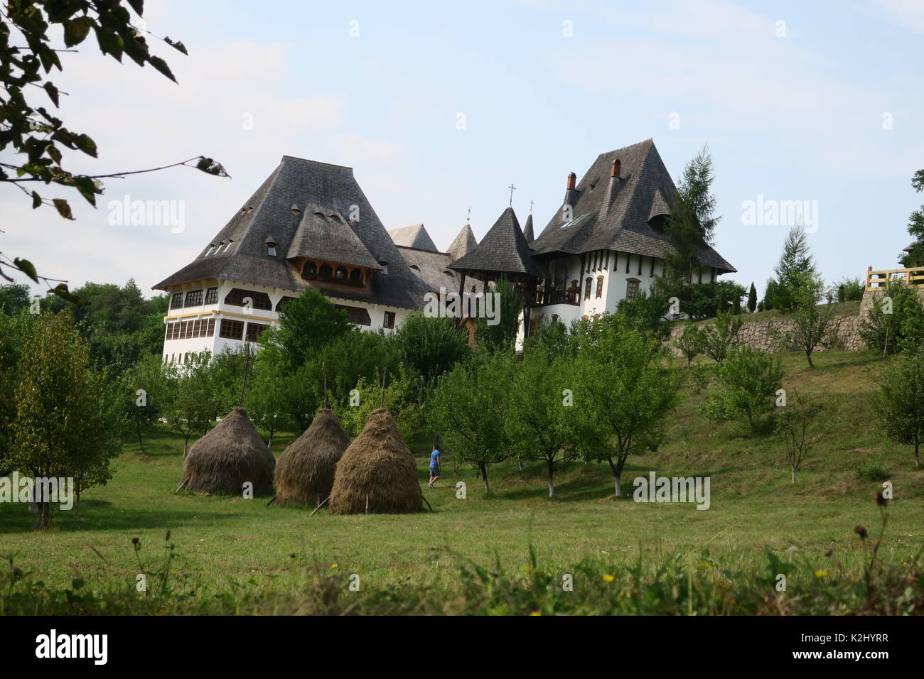 Traditional hay rick on a meadow, in background monastery complex in ...
