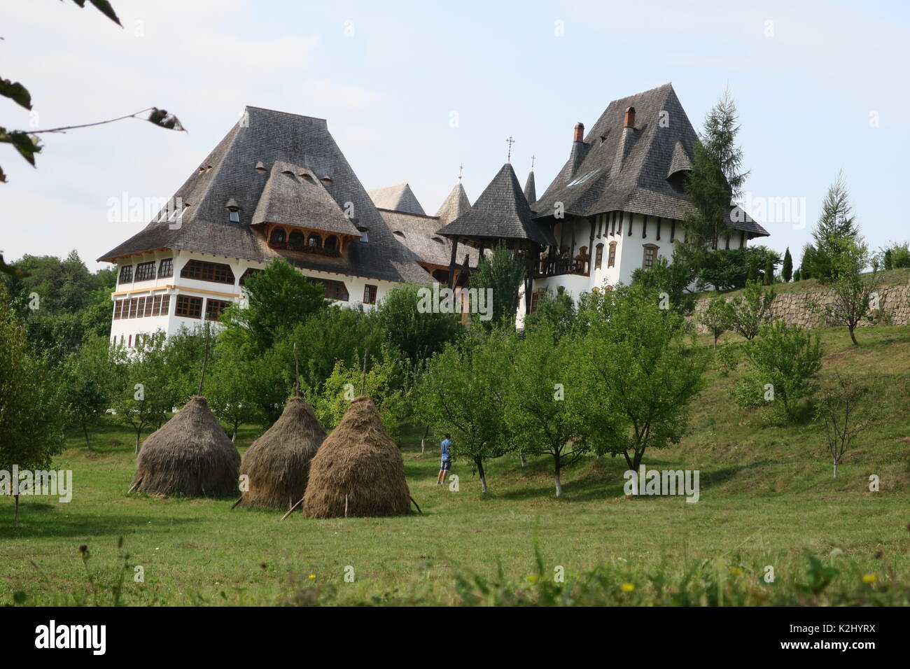 Traditional hay rick on a meadow, in background monastery complex in ...