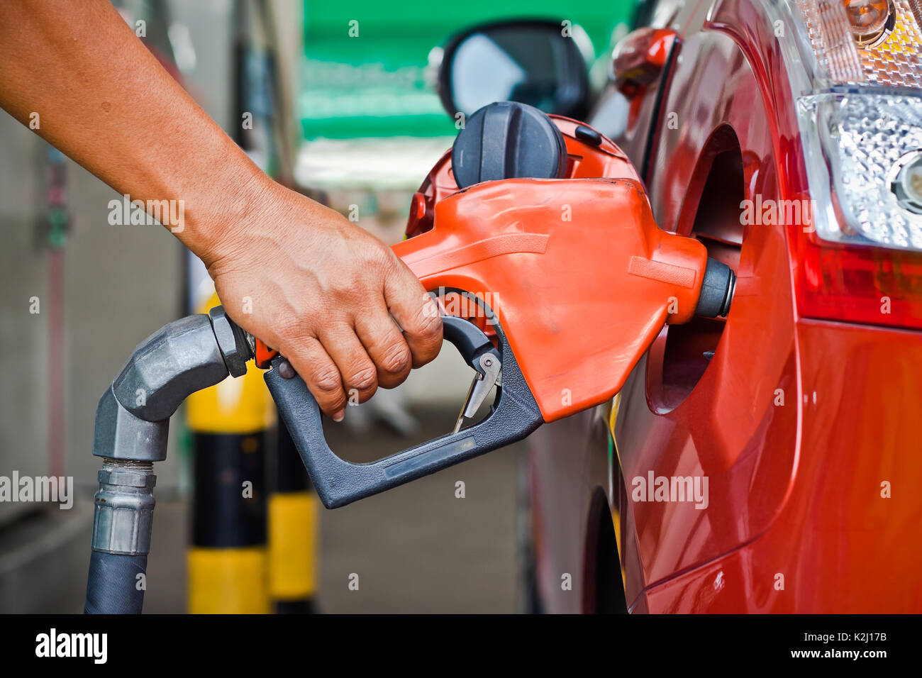 Closeup of a fueling hose at a gas station with a Hand Stock Photo - Alamy
