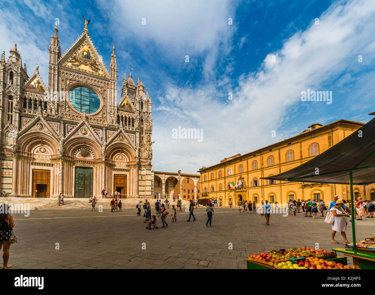 fruit stand among tourists in square of Siena in front of Cathedral ...