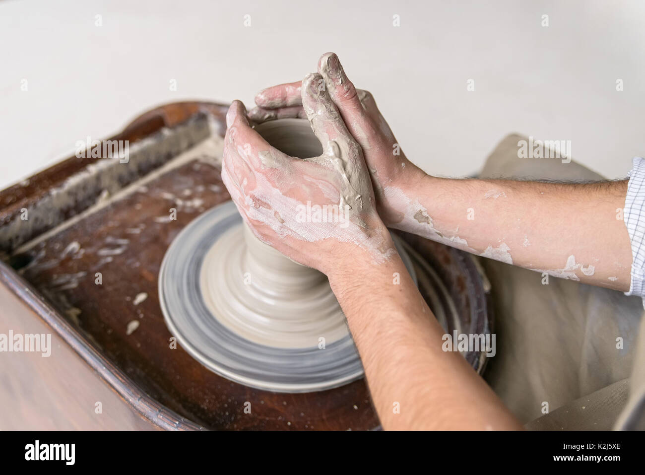 Hands working on pottery wheel Stock Photo - Alamy