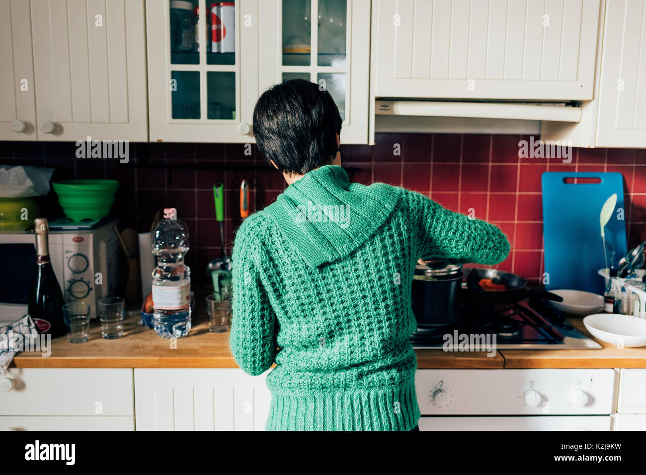Back view of young woman cooking indoor preparing food - chef, food ...