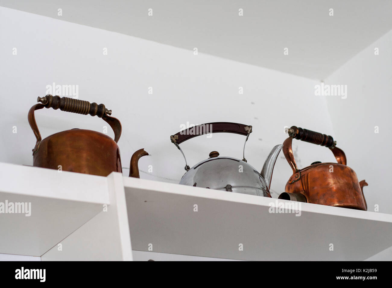 Display of old-fashioned Copper and metal kettles and steam irons 1950s ...