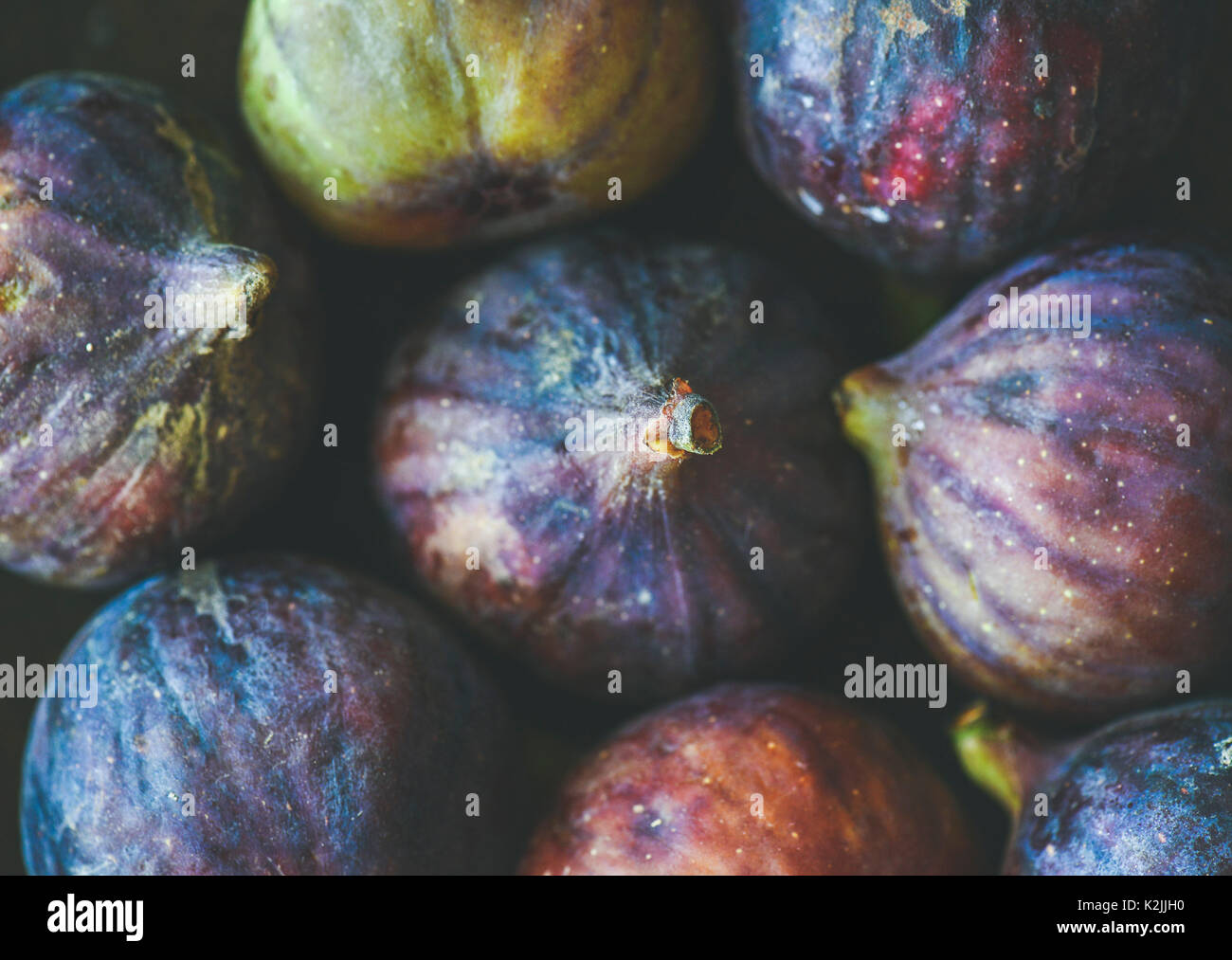 Close-up of fresh ripe purple figs, top view. Food texture and ...