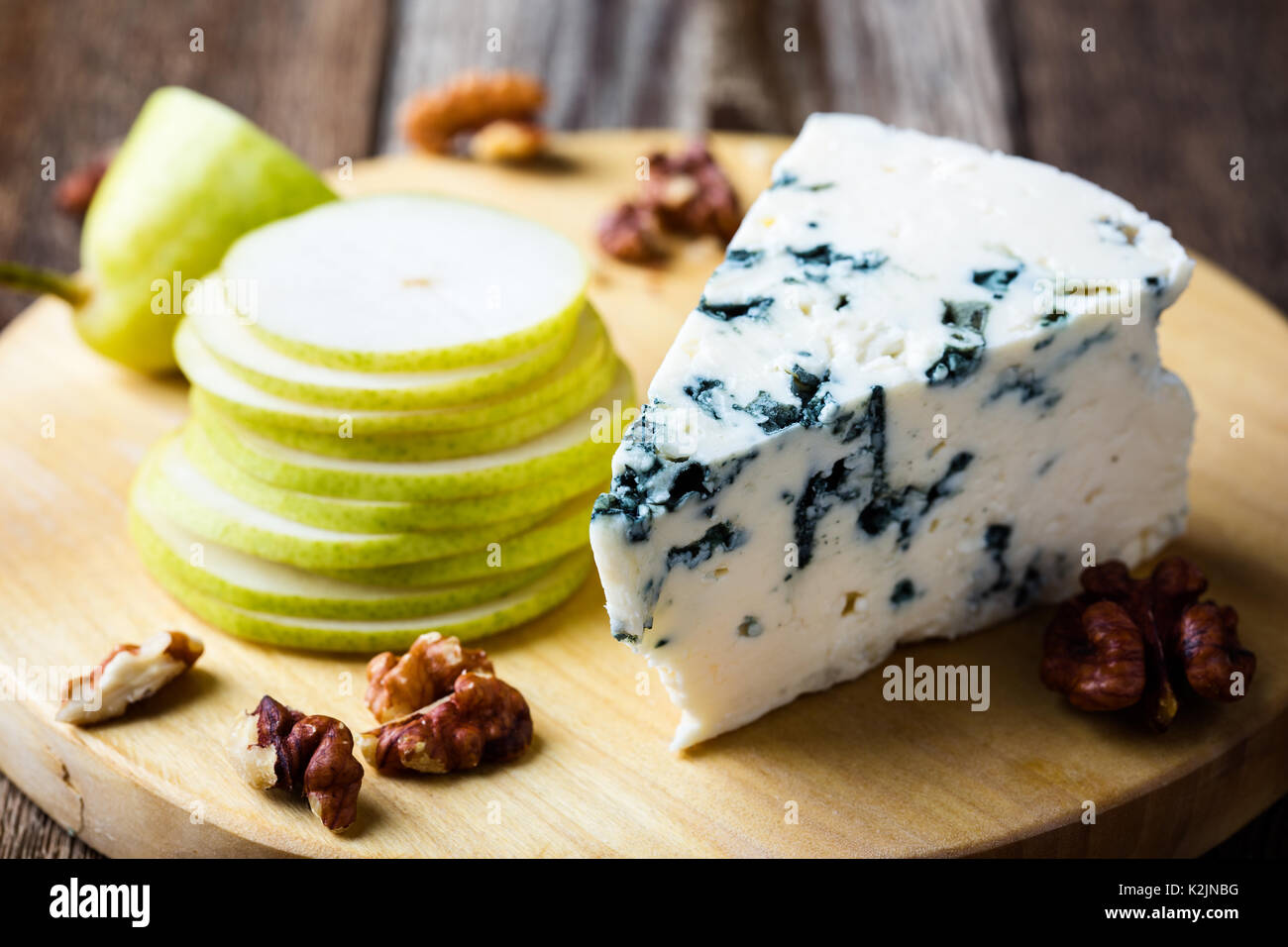 Cheese platter. Blue cheese with fresh pear on rustic wooden board ...