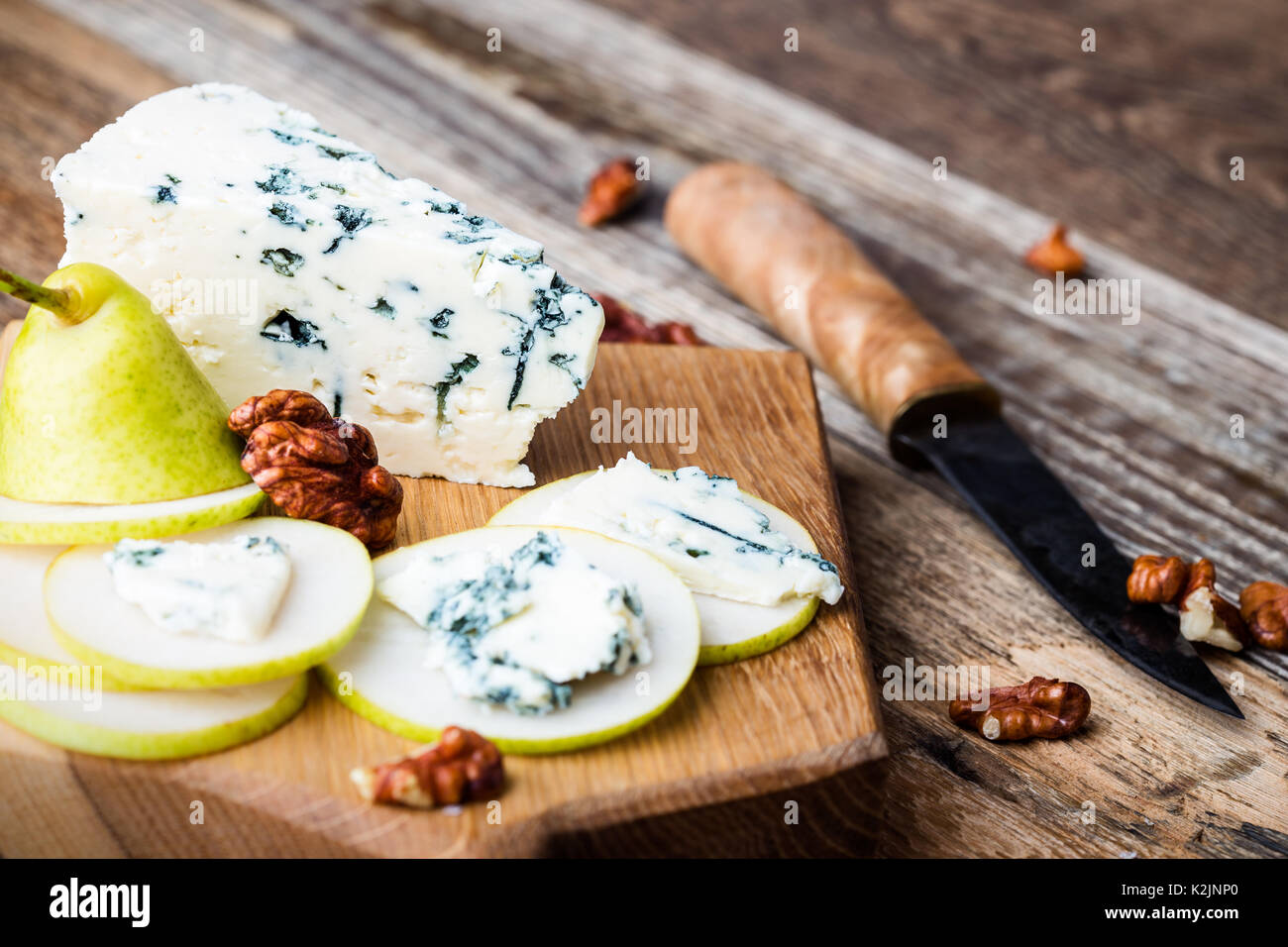 Cheese platter. Blue cheese with fresh pear on rustic wooden board ...