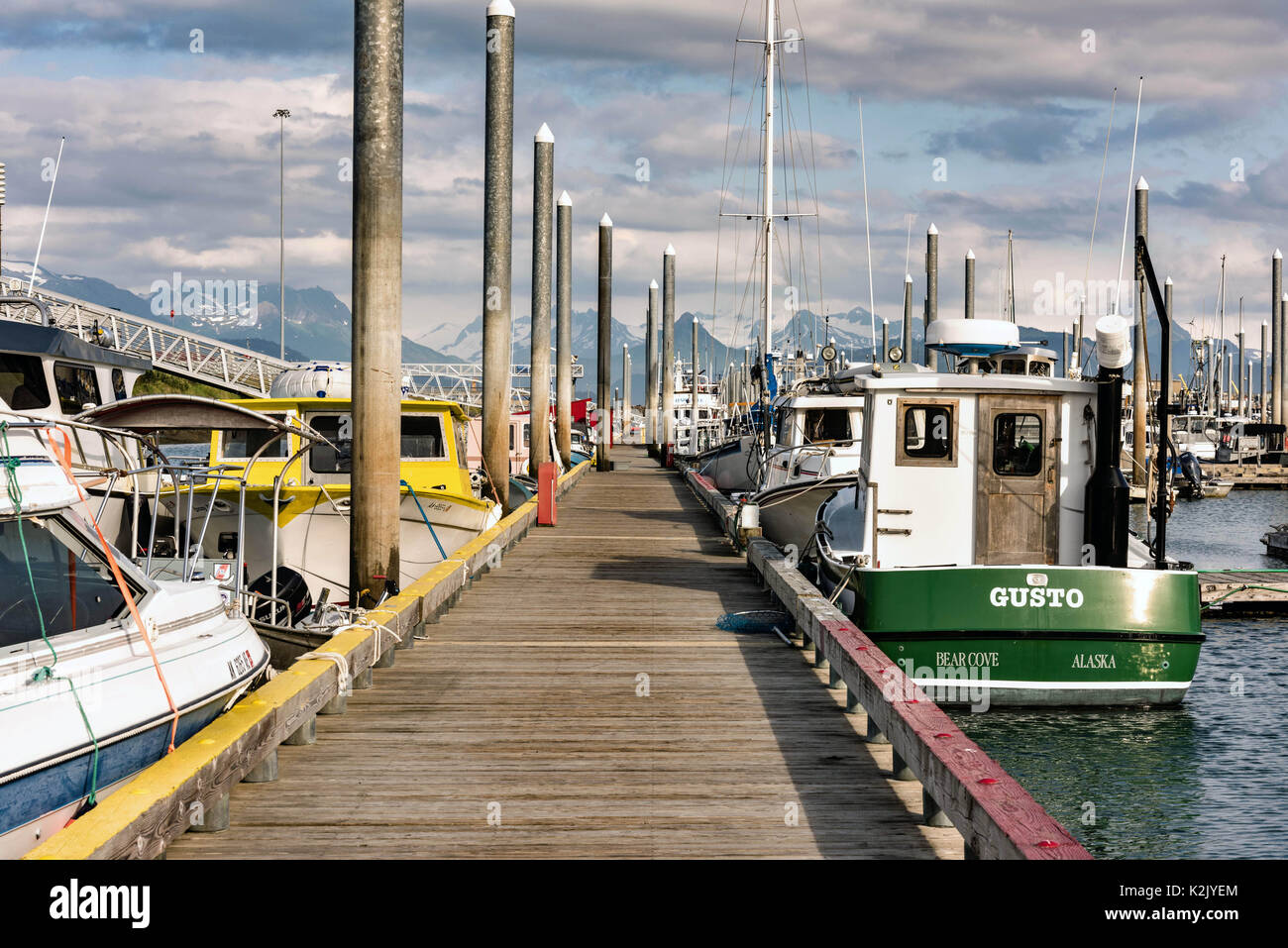 A dock runway between fishing boats docked in the City of Homer Port ...