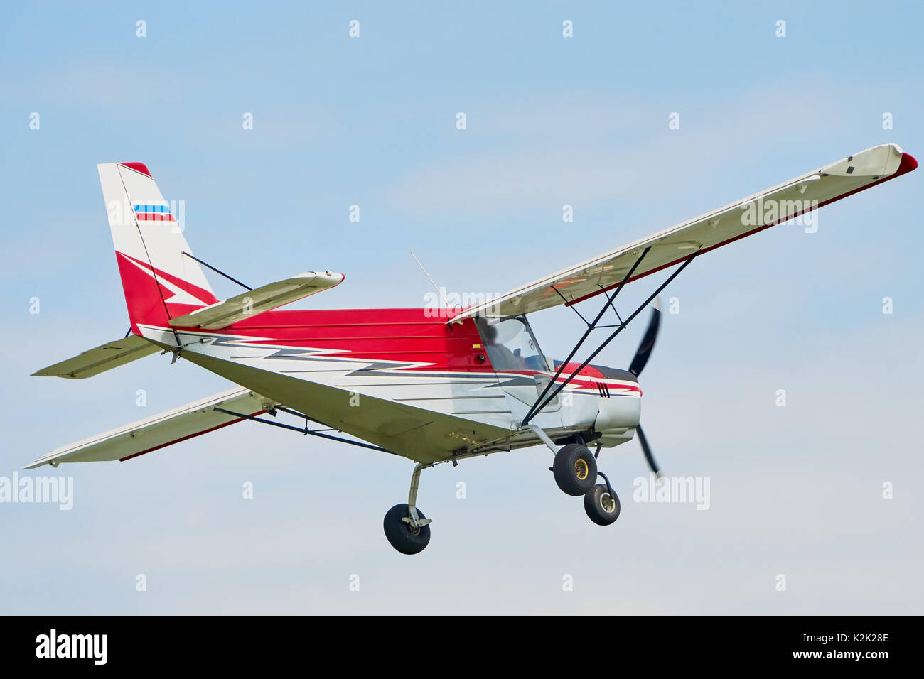 Flying small airplane against a blue sky with a lumpy plan Stock Photo ...