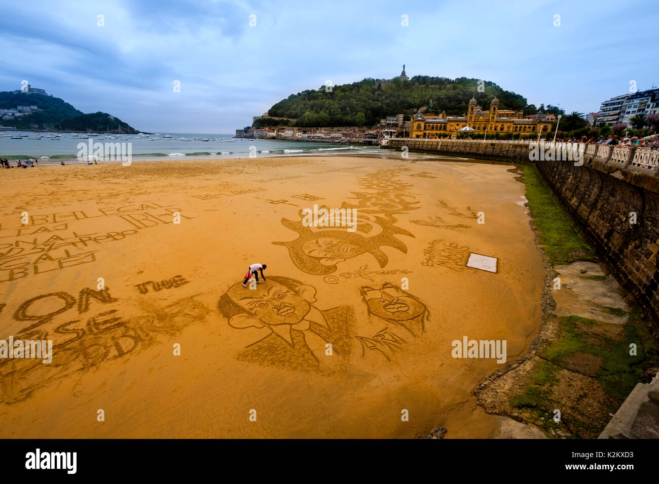 Beach artist drawing in the sand San Sebastian beach Spain Stock Photo ...