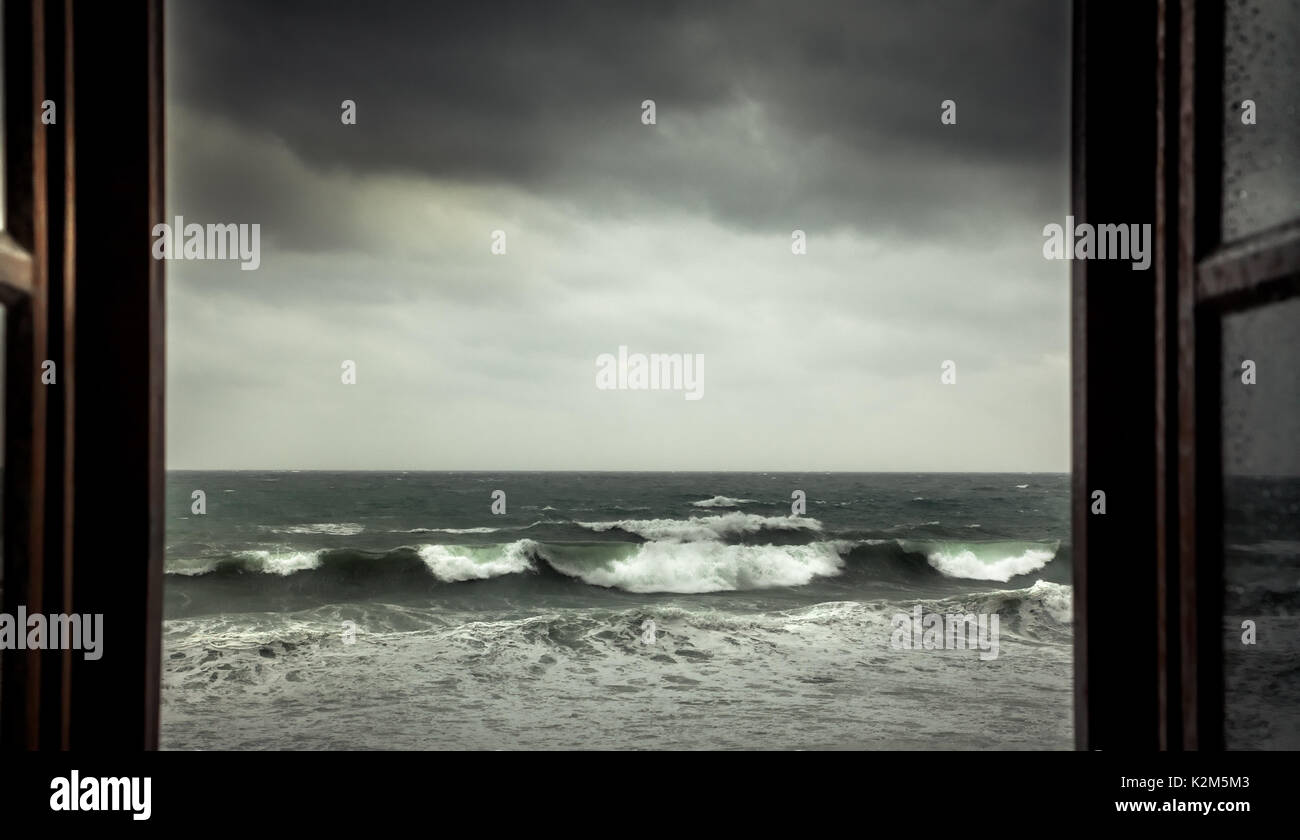 Dramatic sea view from opened window with big stormy waves and dramatic ...