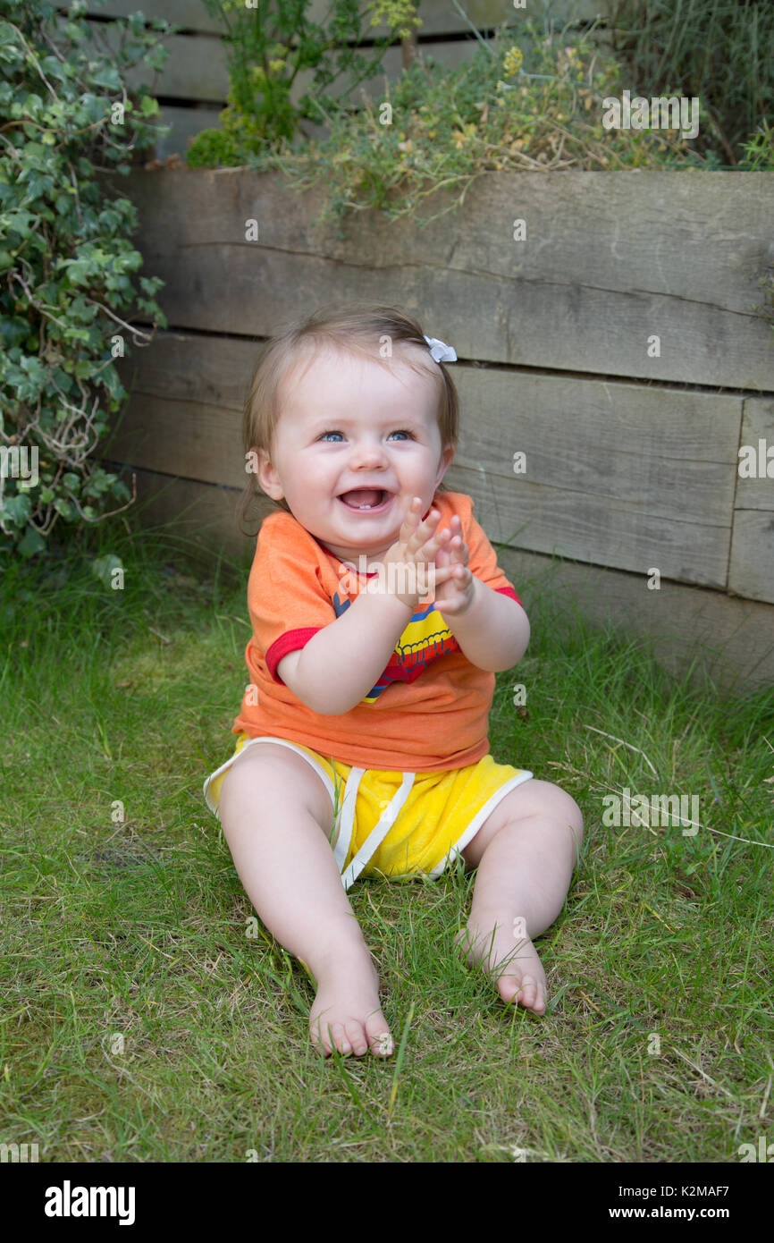 Happy 10 month old baby girl clapping Stock Photo - Alamy