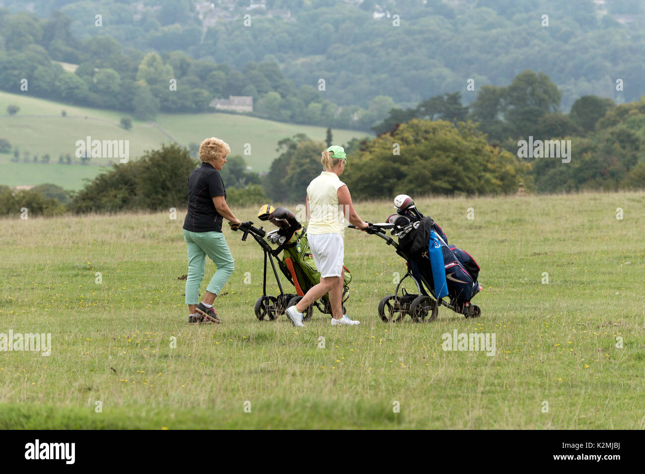 Golfers walking with caddies hi-res stock photography and images - Alamy