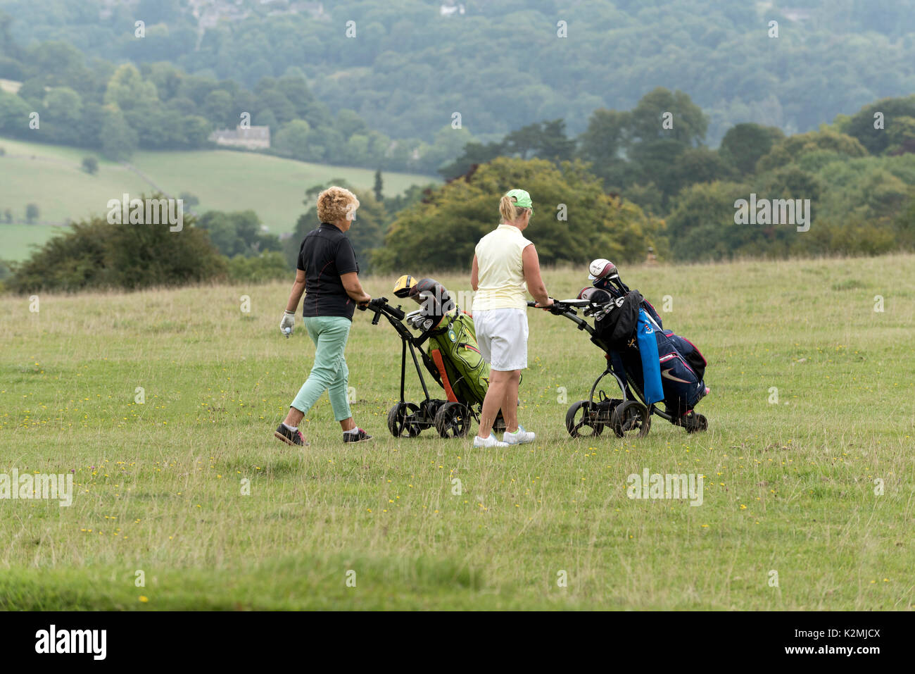 Golfers walking with caddies hi-res stock photography and images - Alamy