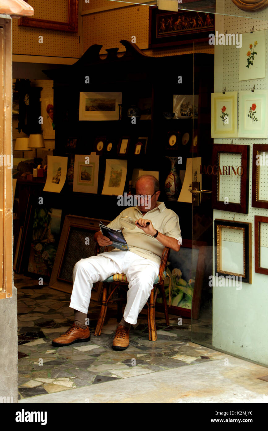 Upright view of man reading in book shop Sorrento Amalfi Coast Italy ...