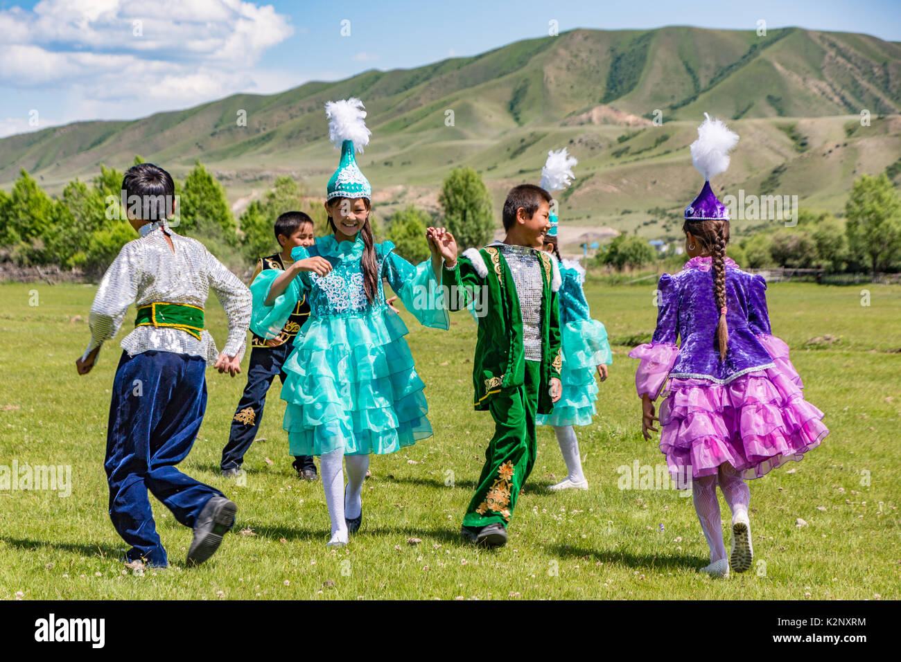 Children play a game in a field, wearing traditional costumes in ...