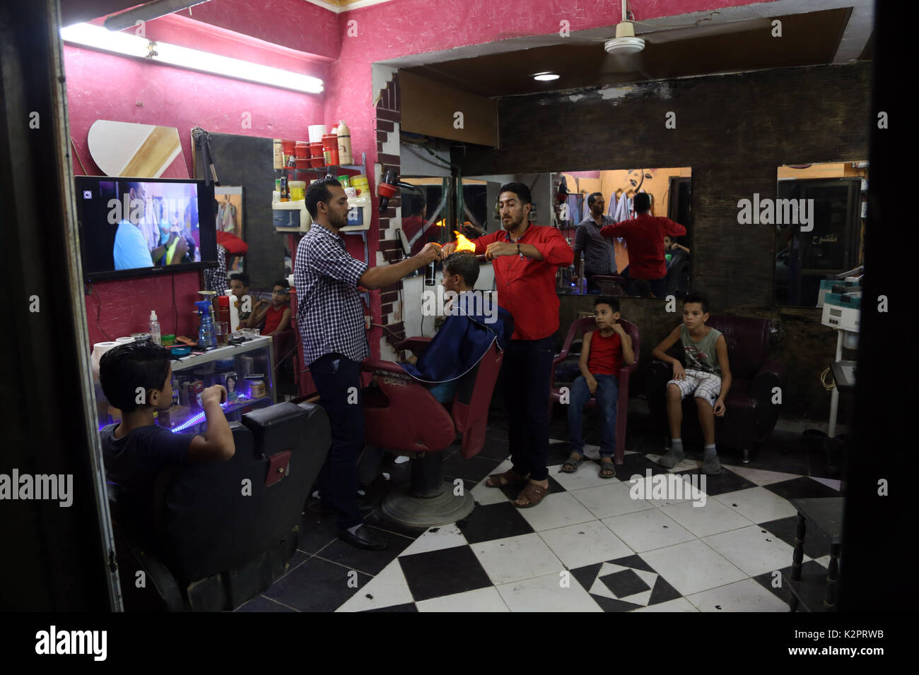Gaza, Egypt. 01st Sep, 2017. Barbers style a client's hair with fire ...