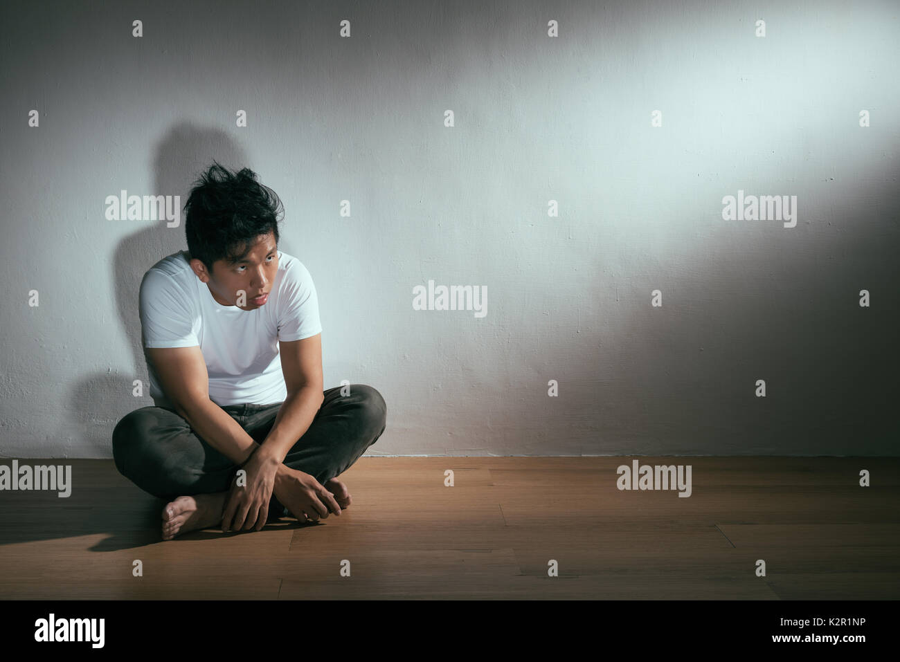 young autism patient man sitting on wooden floor looking at empty ...