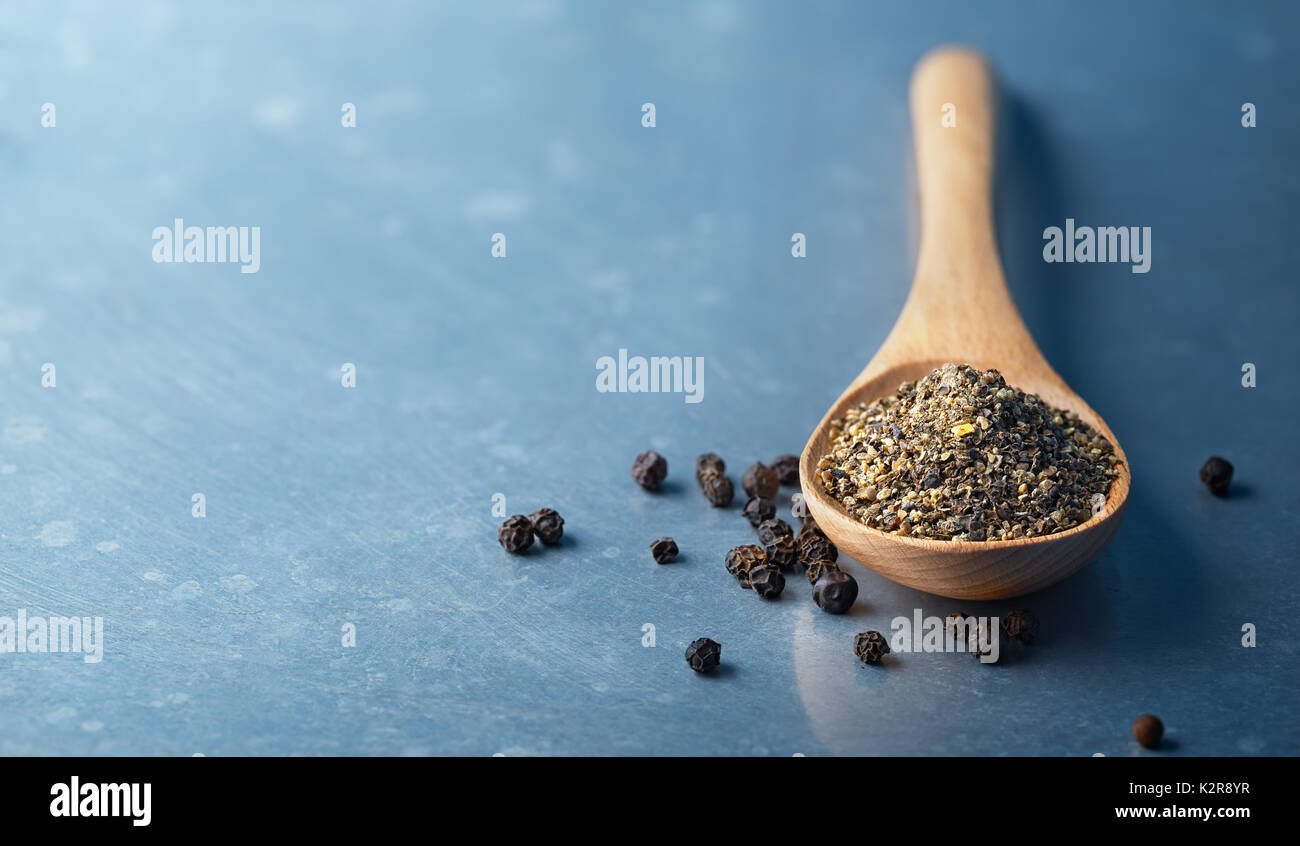 Wooden spoon filled with ground pepper and Black Peppercorns Stock ...
