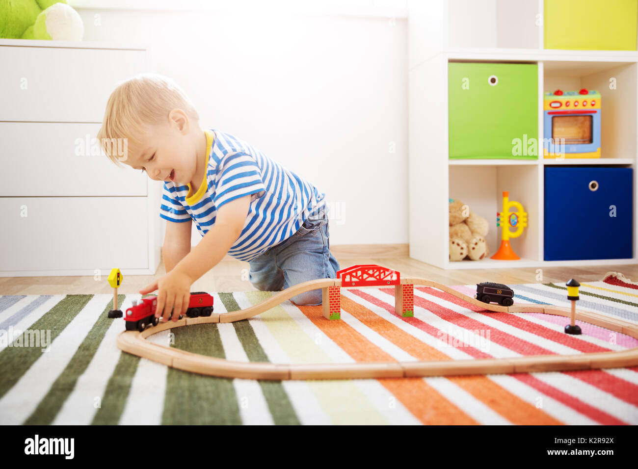 Little child playing with railroad Stock Photo - Alamy