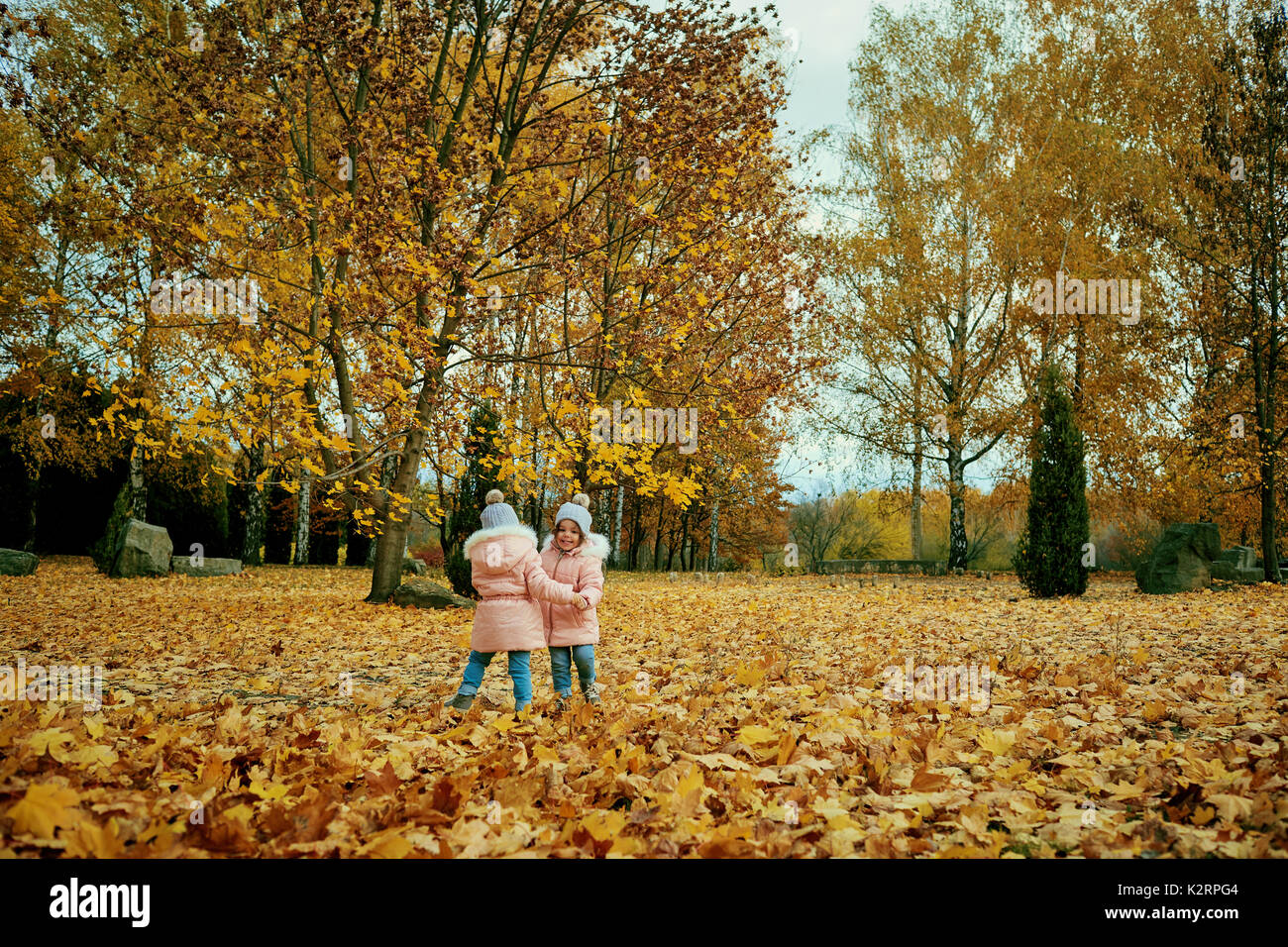 Two happy children playing in autumn clothes in the park Stock Photo ...