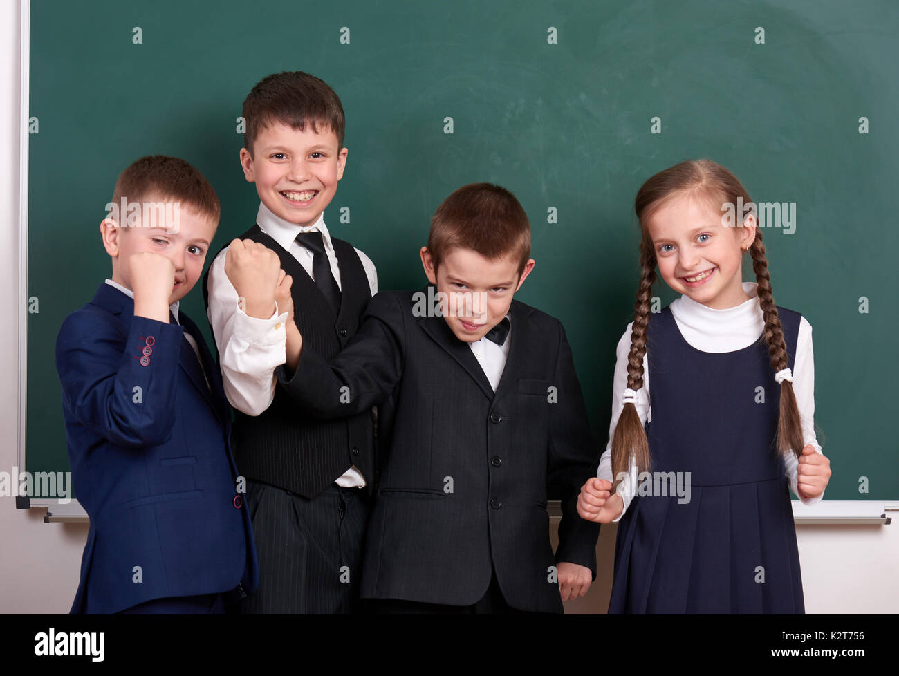 group pupil as a gang, posing near blank chalkboard background ...