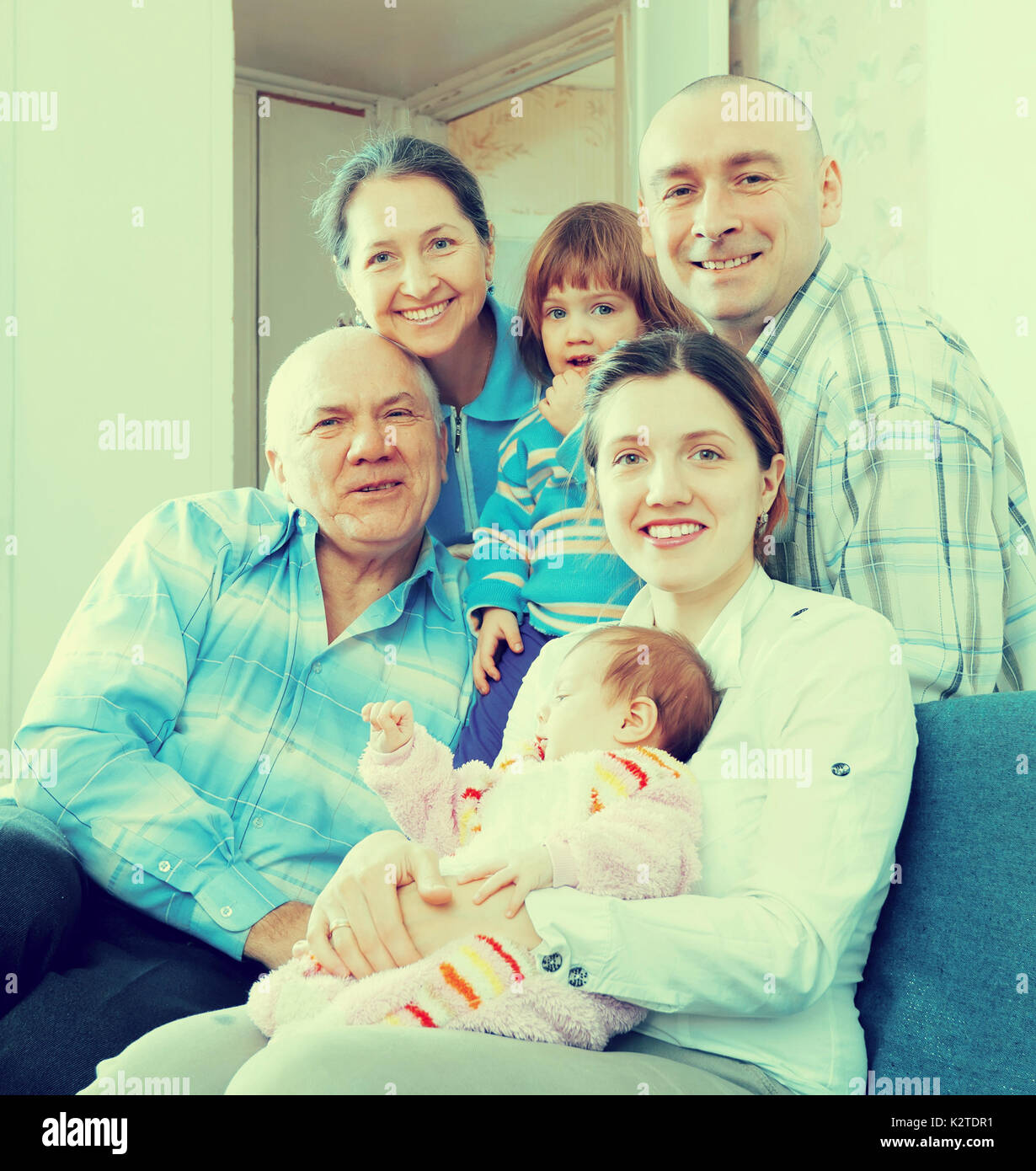 Portrait of smiling happy three generations family with two children at ...