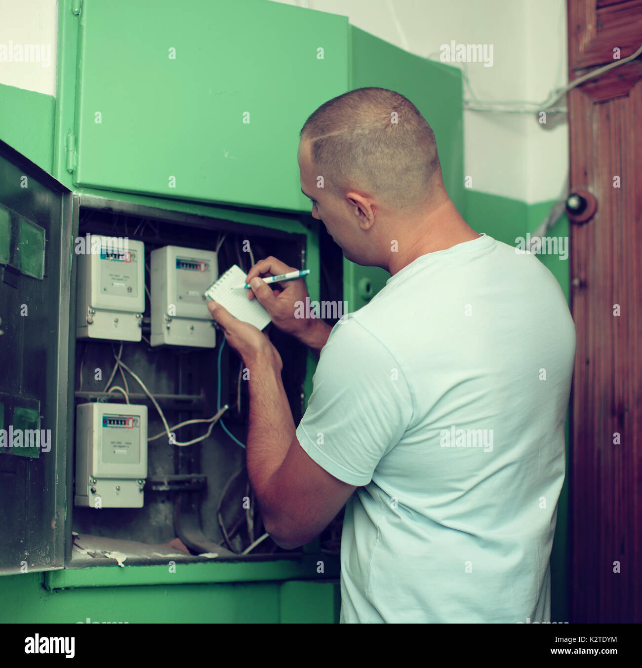 Man rewrites the electrical meter readings Stock Photo - Alamy