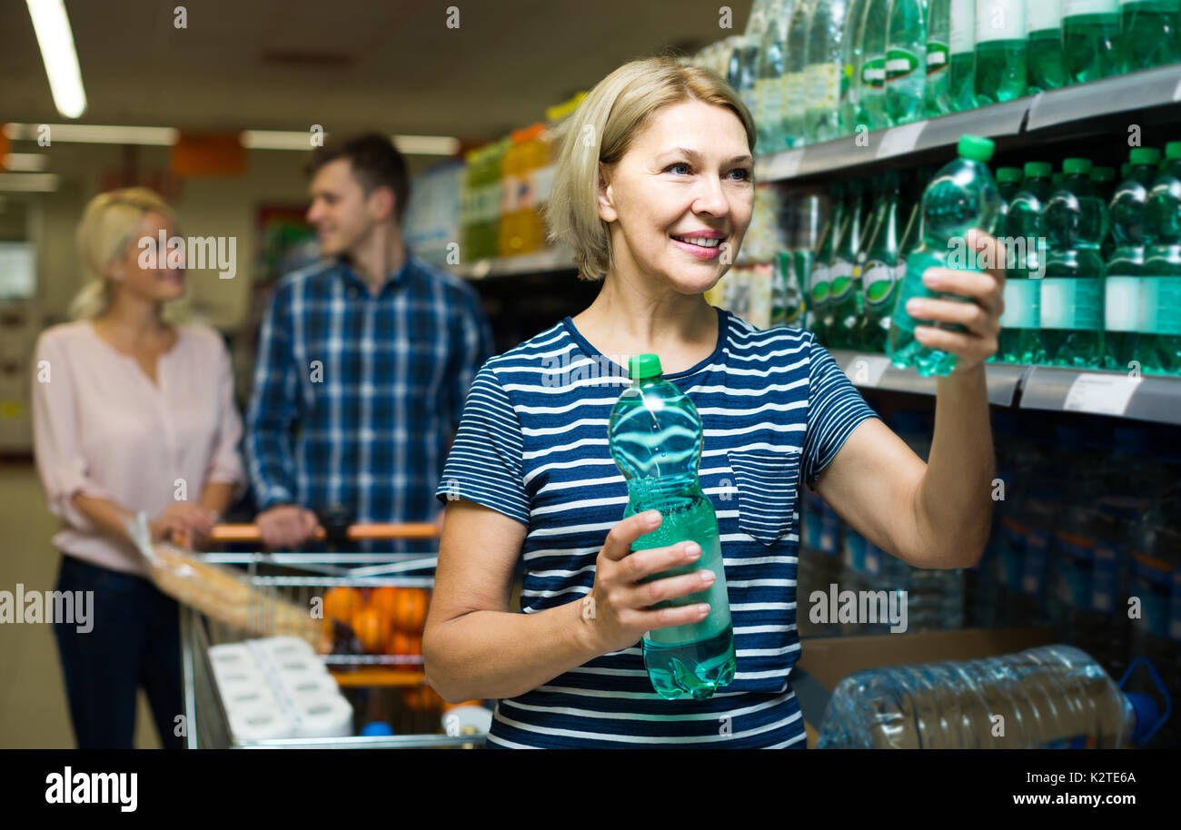happy european clients buying bottle of still water in supermarket ...