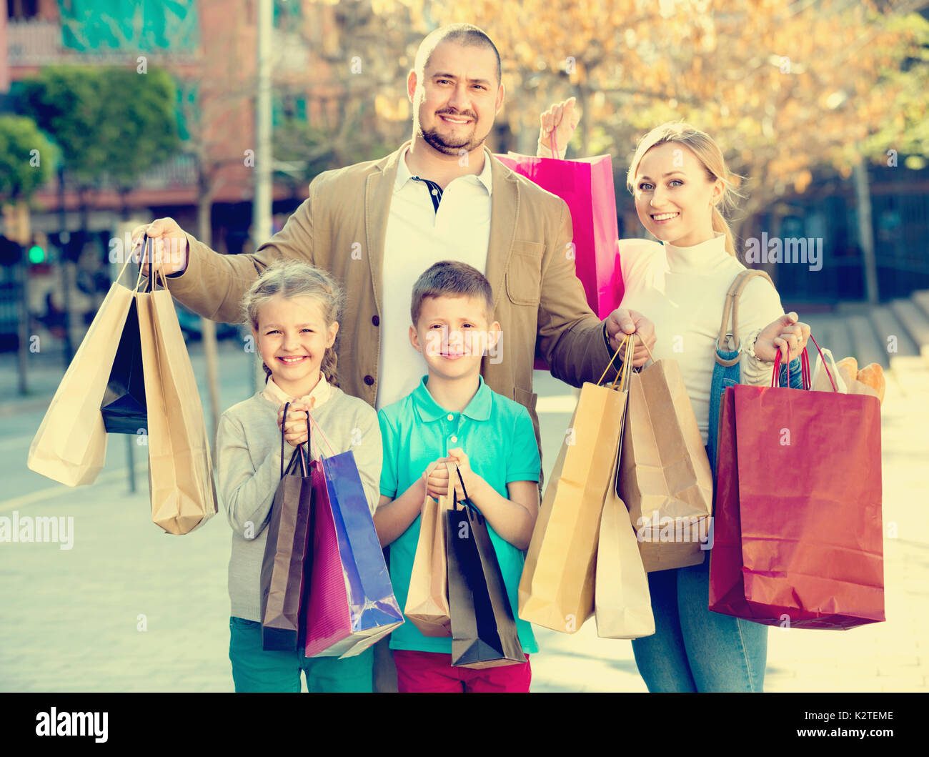 Young happy smiling parents with two teenagers going for a shopping ...