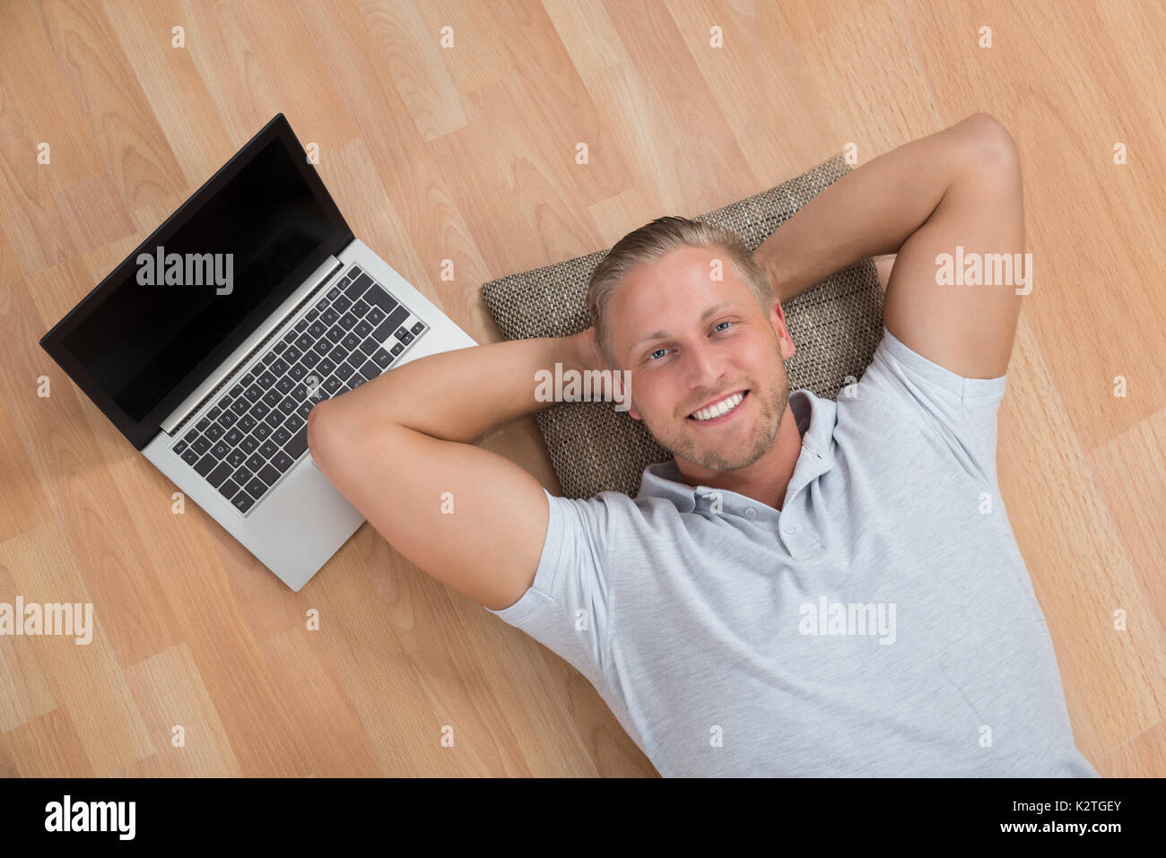 Young Happy Man Lying On Floor With Laptop Stock Photo - Alamy