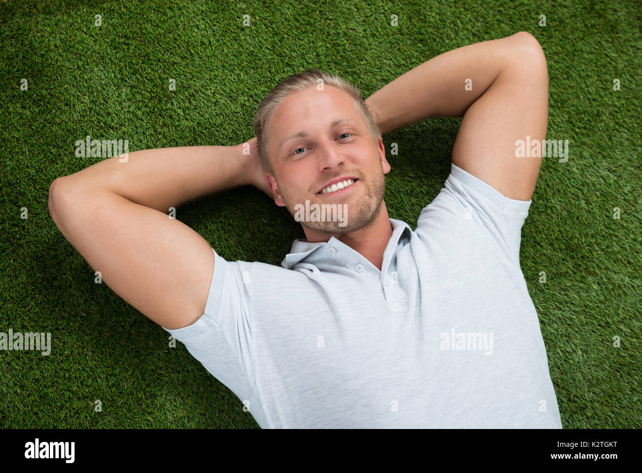 Man lying on grass smiling hi-res stock photography and images - Alamy