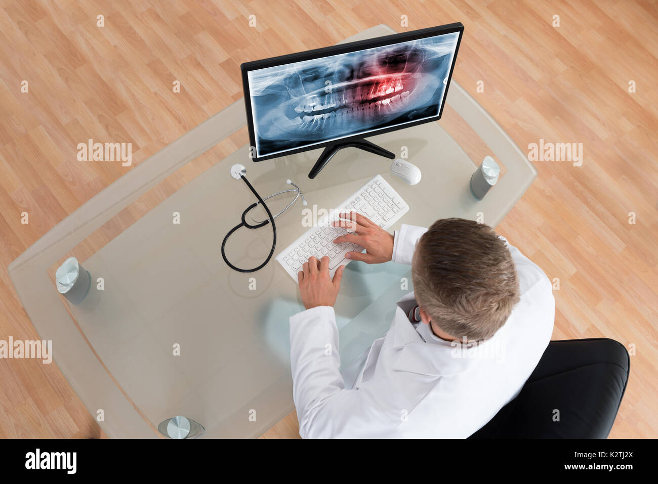 Young Doctor Examining Teeth X-ray On Computer At Desk Stock Photo - Alamy