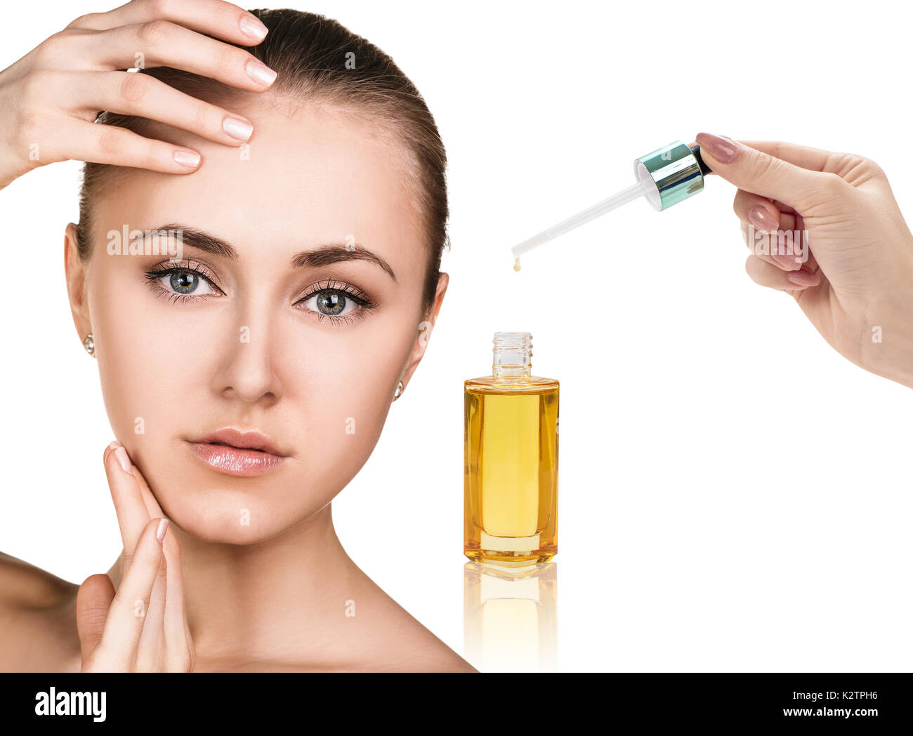 Cosmetic oil applying on face of young woman Stock Photo - Alamy