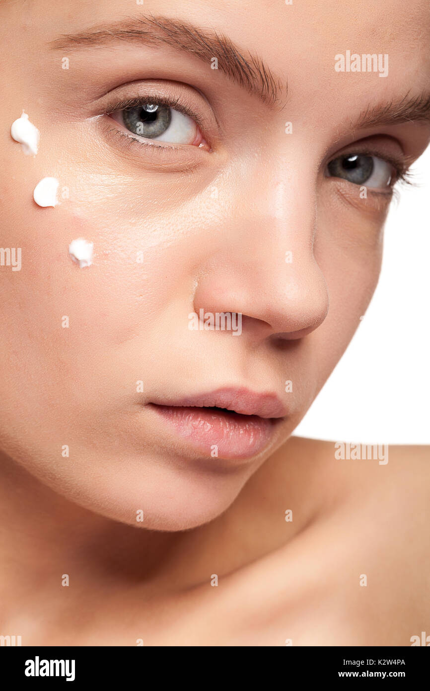 Portrait of Gorgeous beautiful woman with cream face drops on her face ...