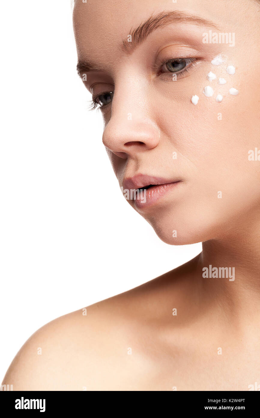 Portrait of Gorgeous beautiful woman with cream face drops on her face ...