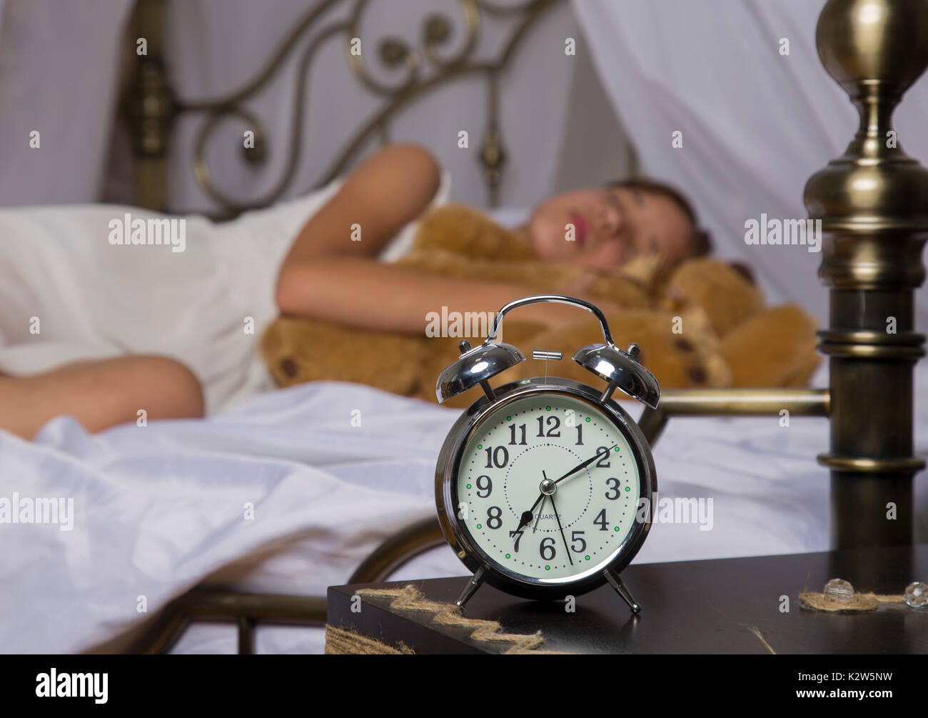 Early awakening. Alarm clock standing on bedside table. Wake up of an ...