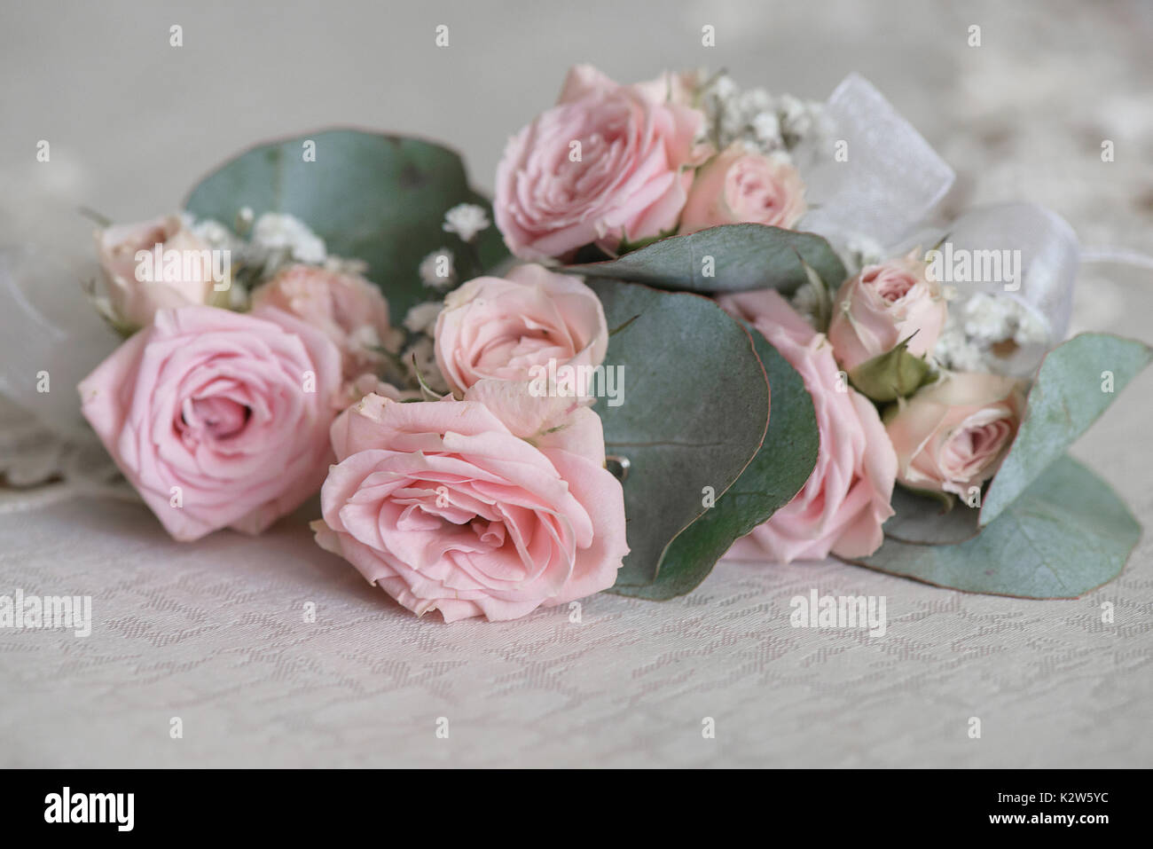 Withered dusky pink roses and over-sized leaves bouquet, on a table ...