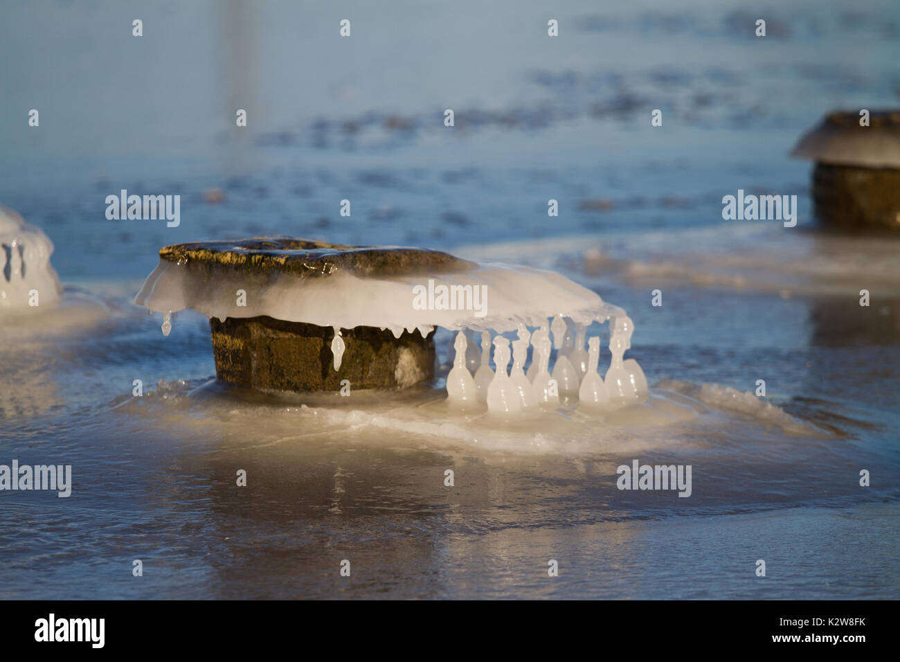 Frozen water on old waterbreaker poles Stock Photo - Alamy