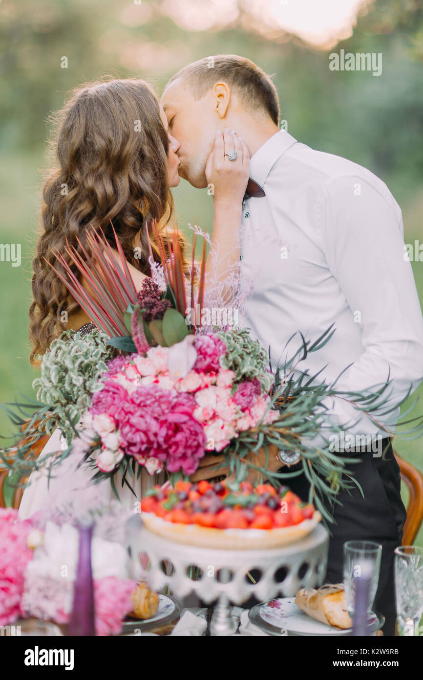 The close-up portrait of kissing bridesmaid and the best man behind the ...