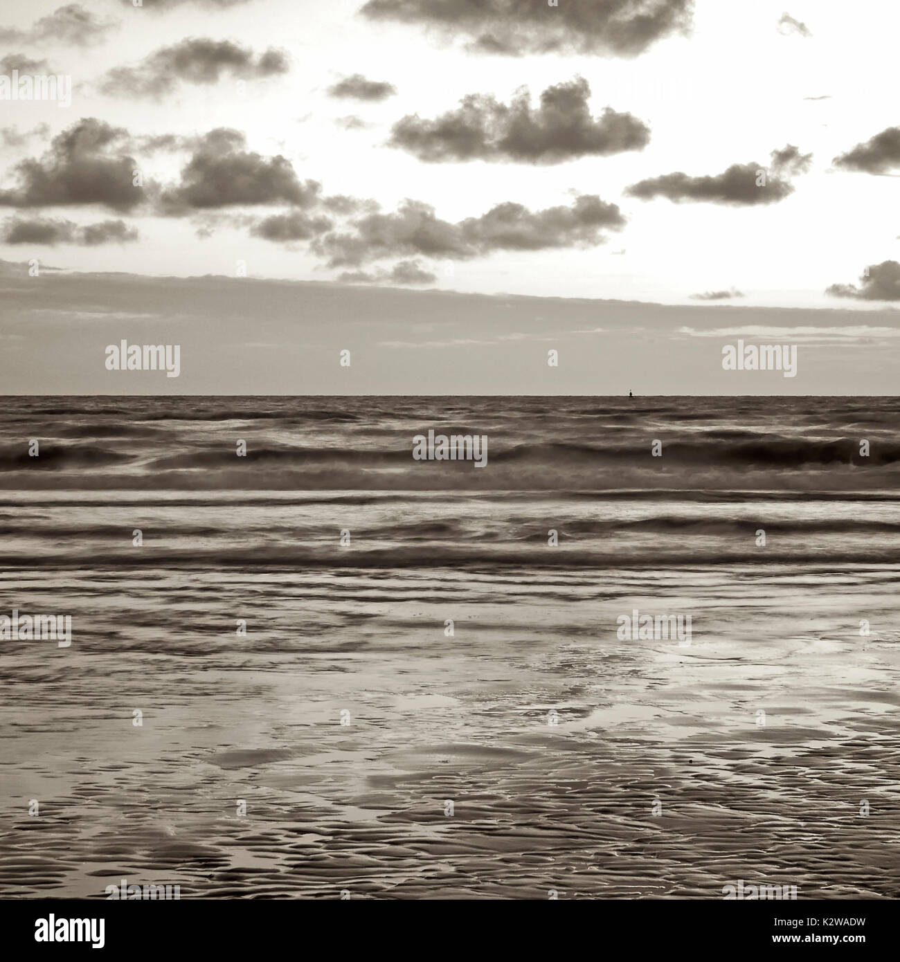 Tide coming in at sunset Stock Photo - Alamy