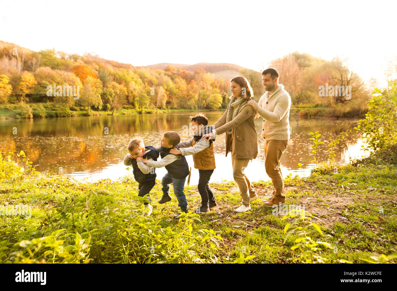 Beautiful young family on a walk in autumn forest Stock Photo - Alamy