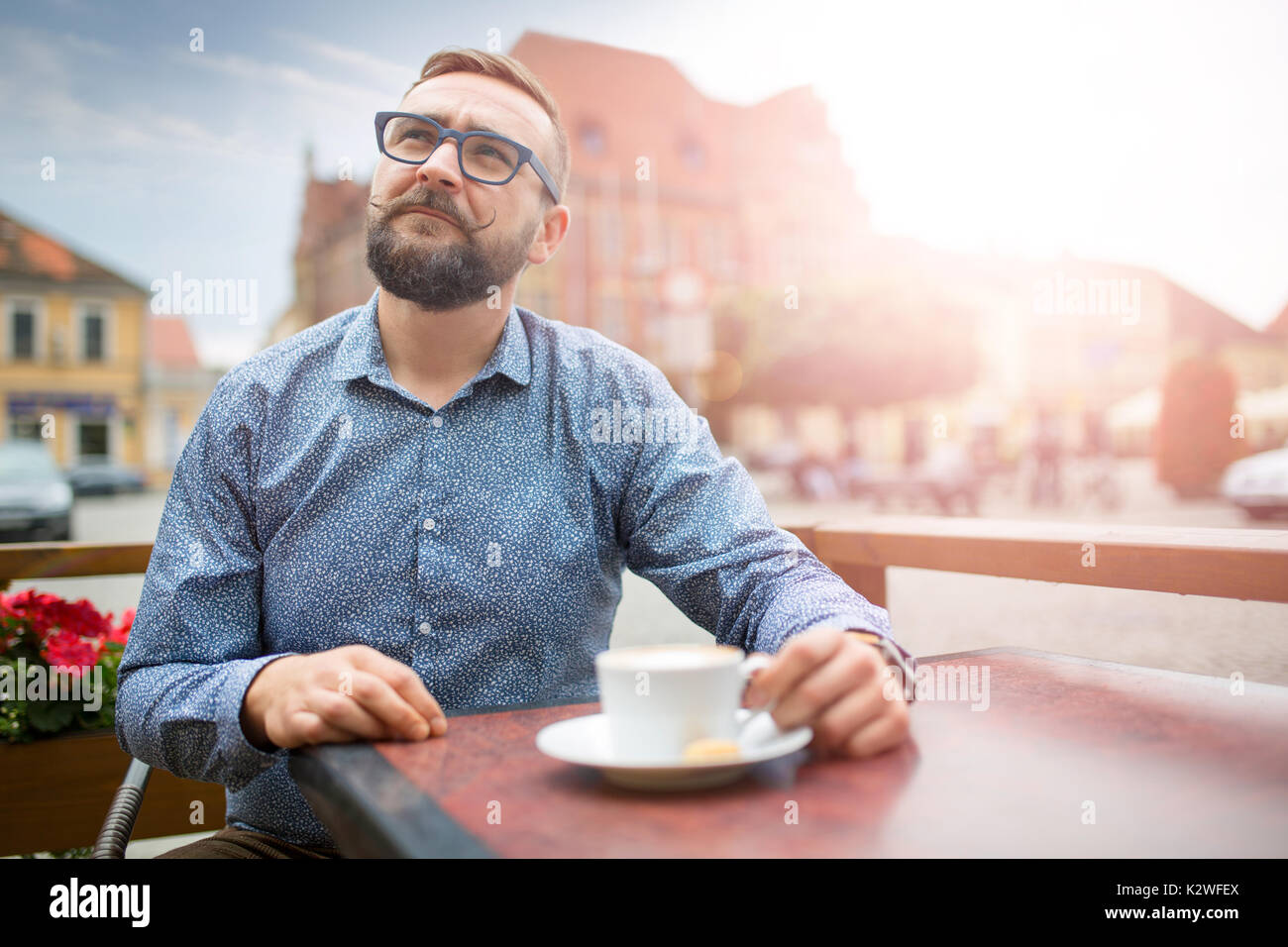 Fashion man sitting in a cafe at market square in sunset Stock Photo ...