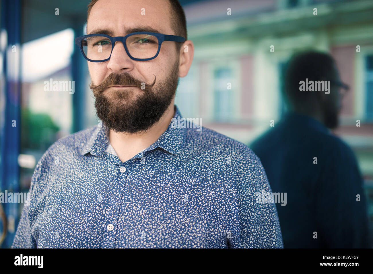 Man standing outside glass building Stock Photo - Alamy