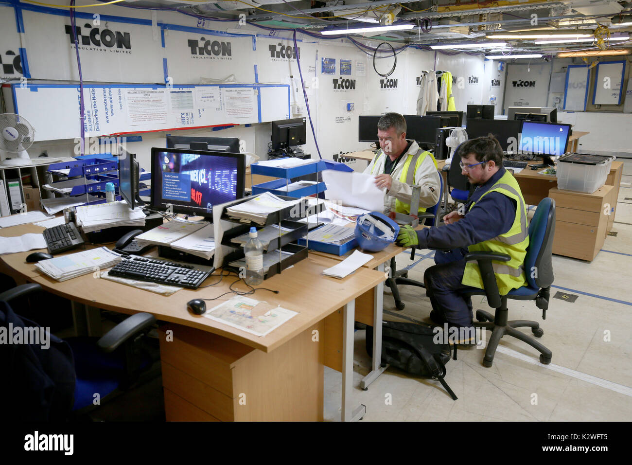 Workers inside the temporary office areas below deck of the HMS Prince ...