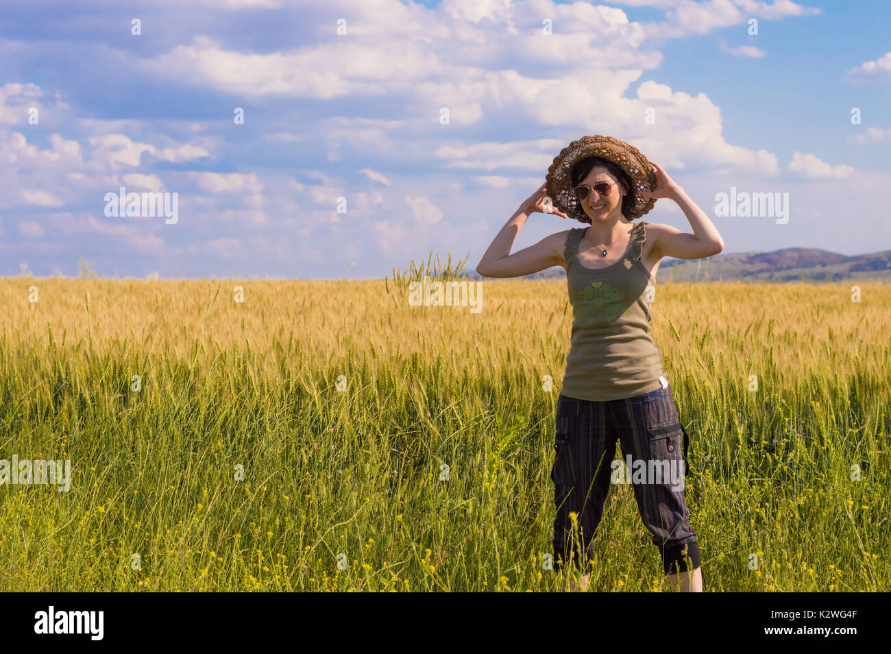 Caucasian woman with hands behind head, making a grimace under the ...