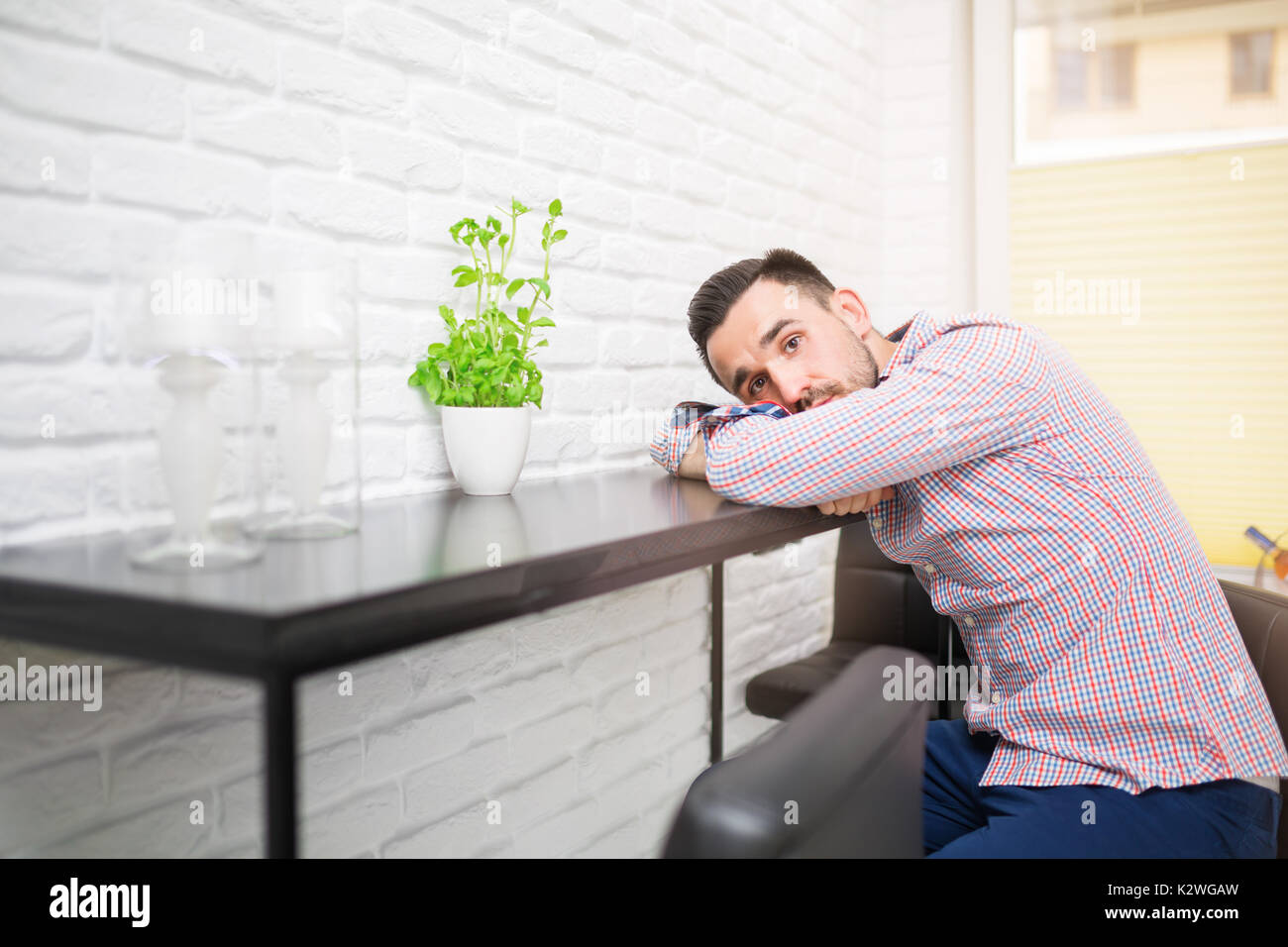 Calm man sitting in kitchen and lying his head on kitchen table Stock ...