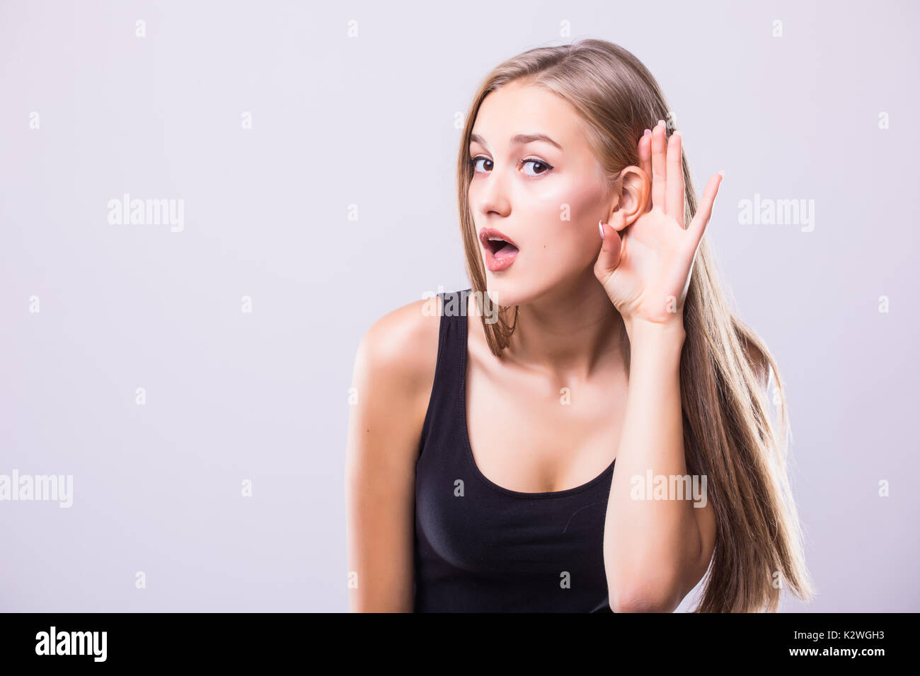 Close up Woman holds her hand near ear and listens carefully isolated ...