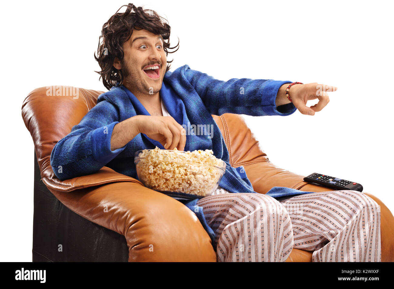 Retro guy seated in an armchair watching television and laughing ...
