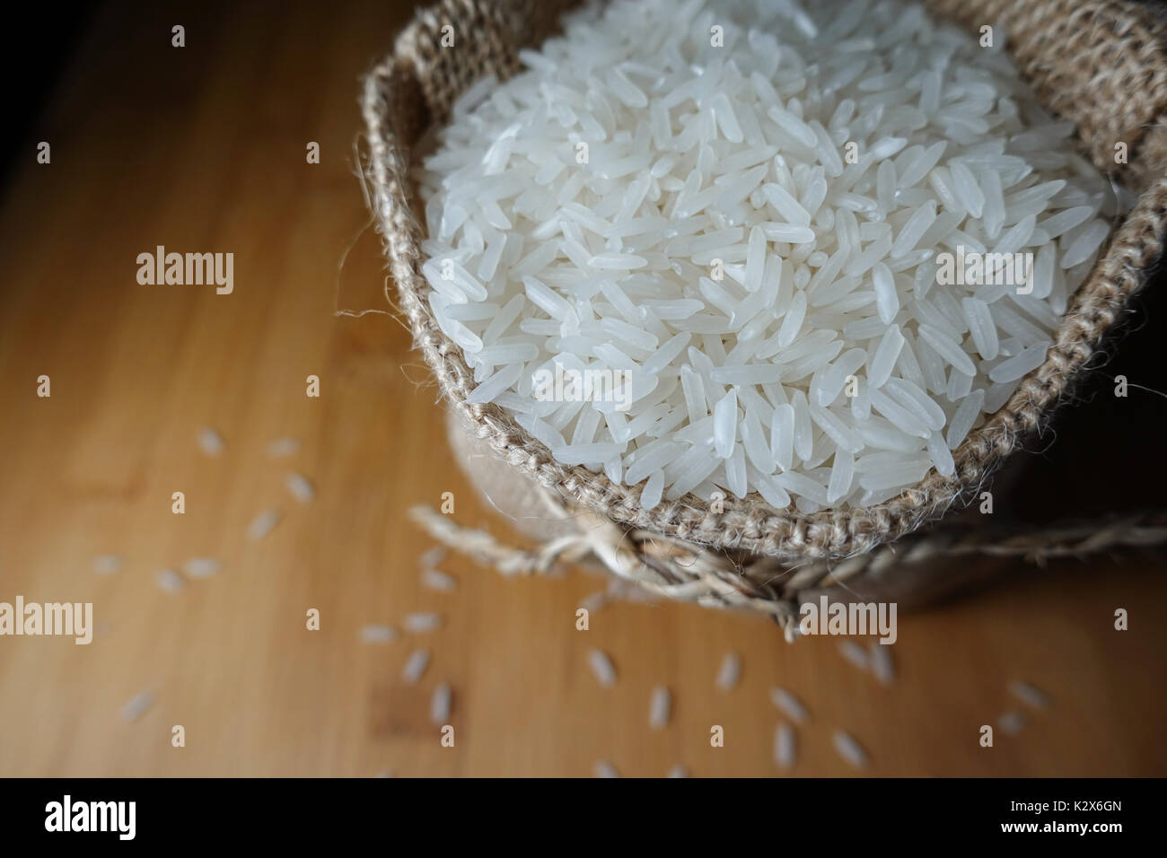 rice in burlap sack on wooden table - closeup Stock Photo - Alamy