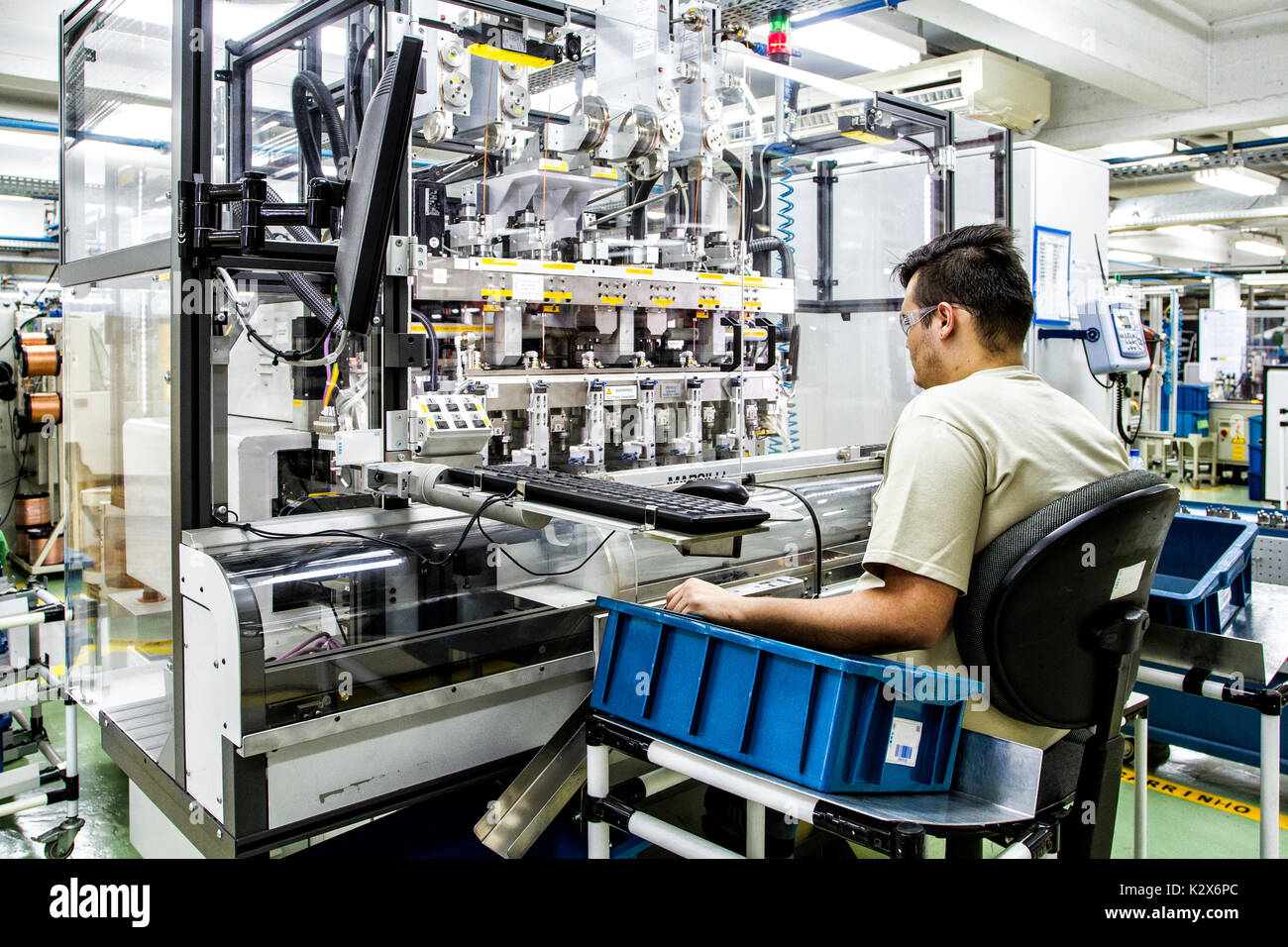 Man operating an automatic winding machine in an industrial plant in ...